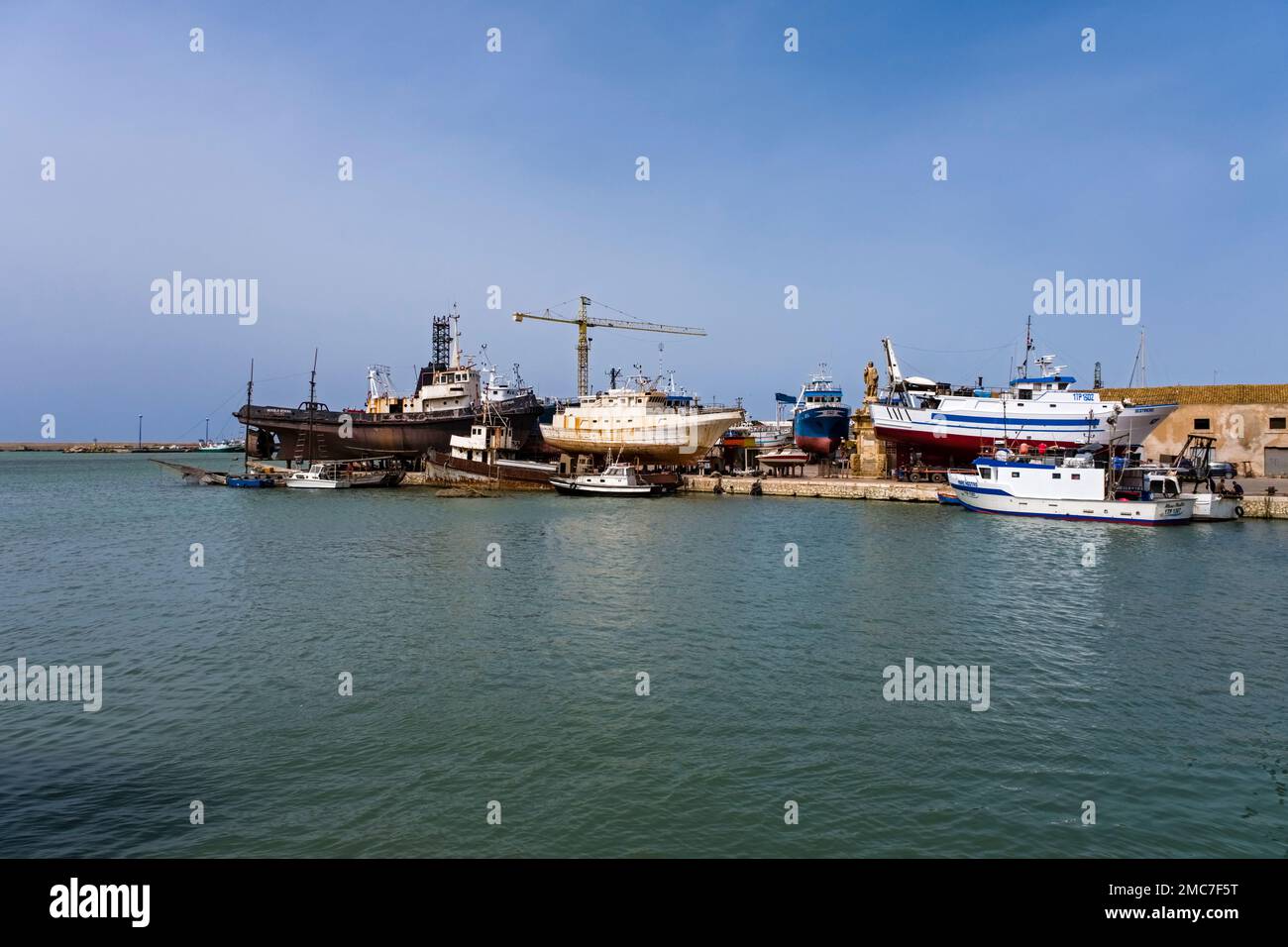 Docks, cranes and fishing boats in the harbour of Marsala, a major town ...