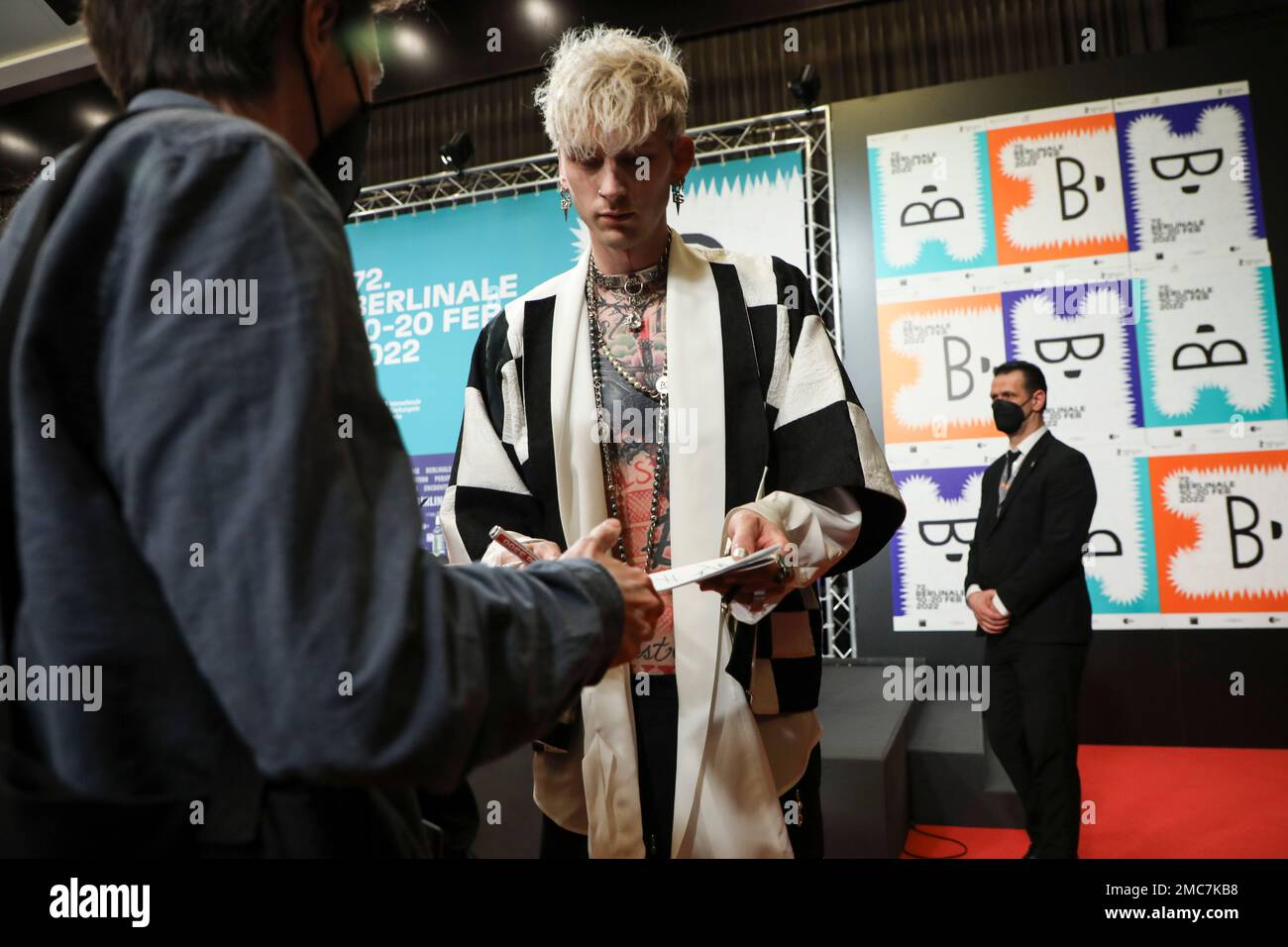 Colson Baker, also known as Machine Gun Kelly, signs an autograph as he ...