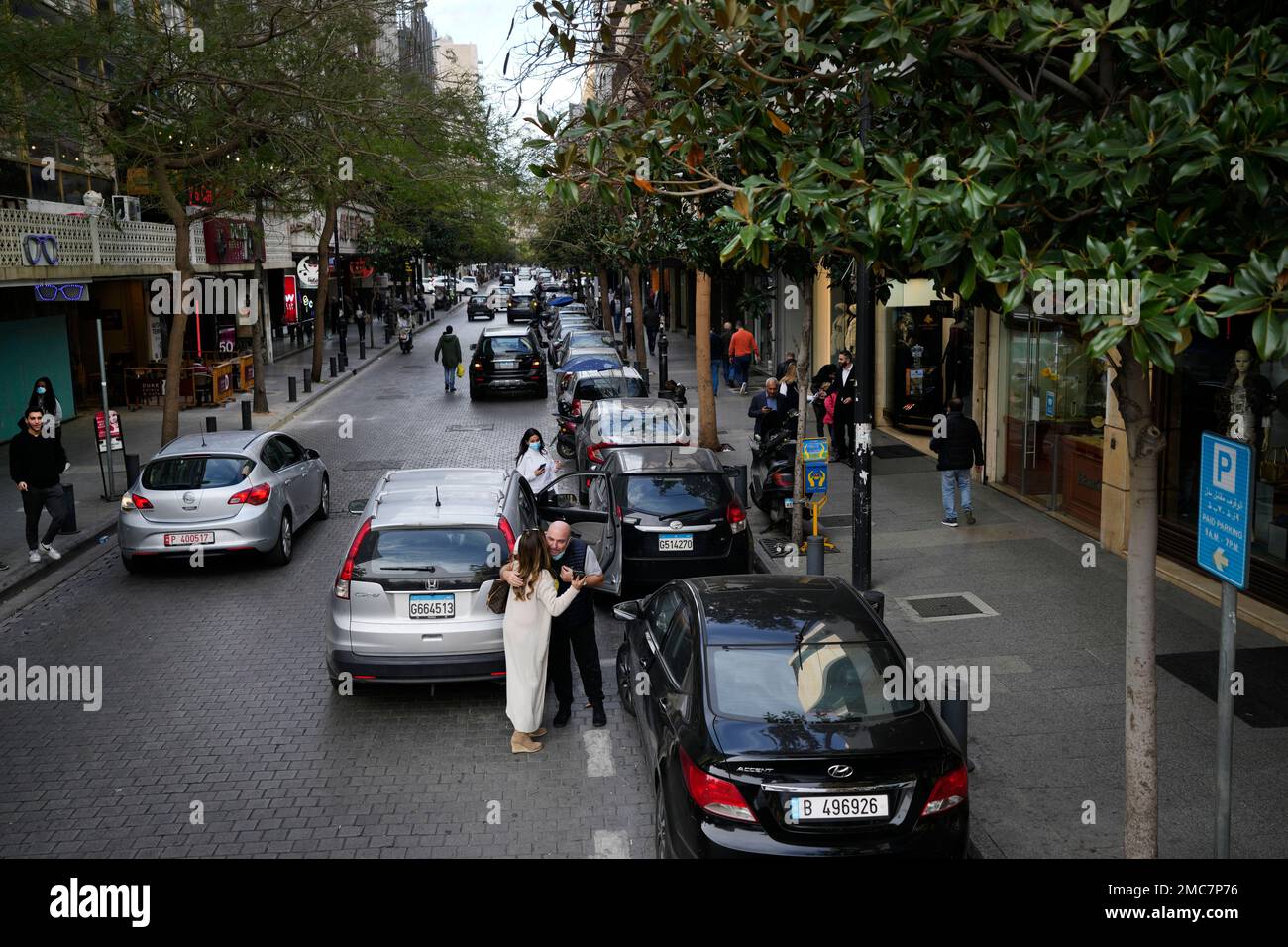 A couple hug each other as other people pass at Hamra Street, in Beirut ...