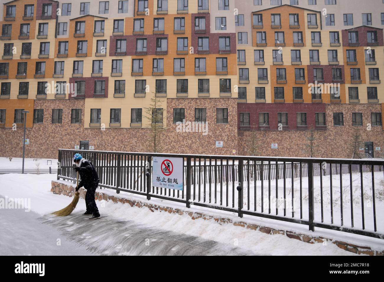 A worker sweeps away snow during a snowstorm at a hotel complex at the ...