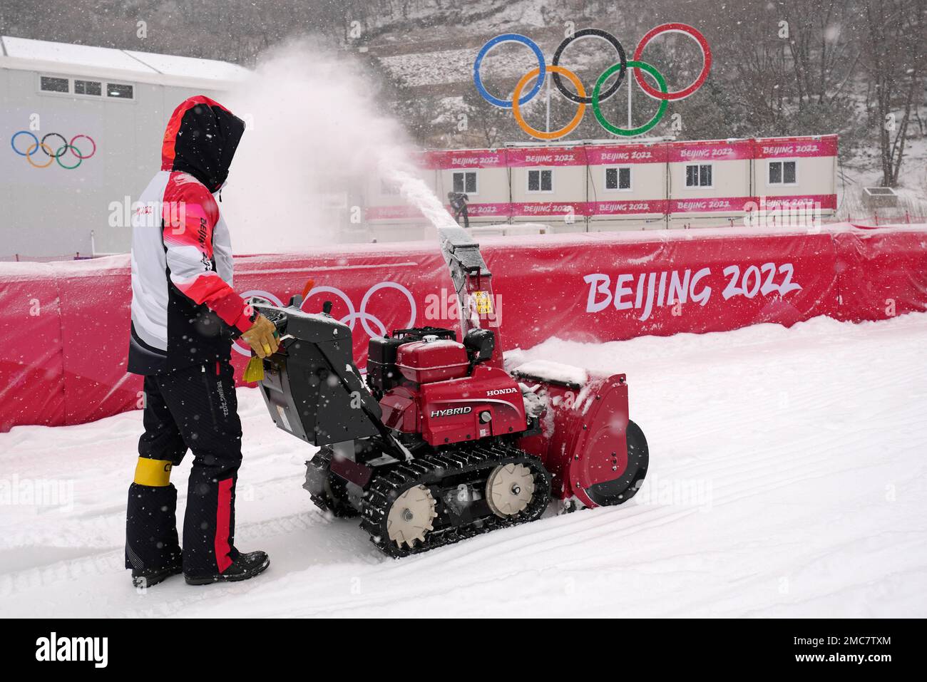 A worker clears snow from inside the finish area of the alpine ski ...