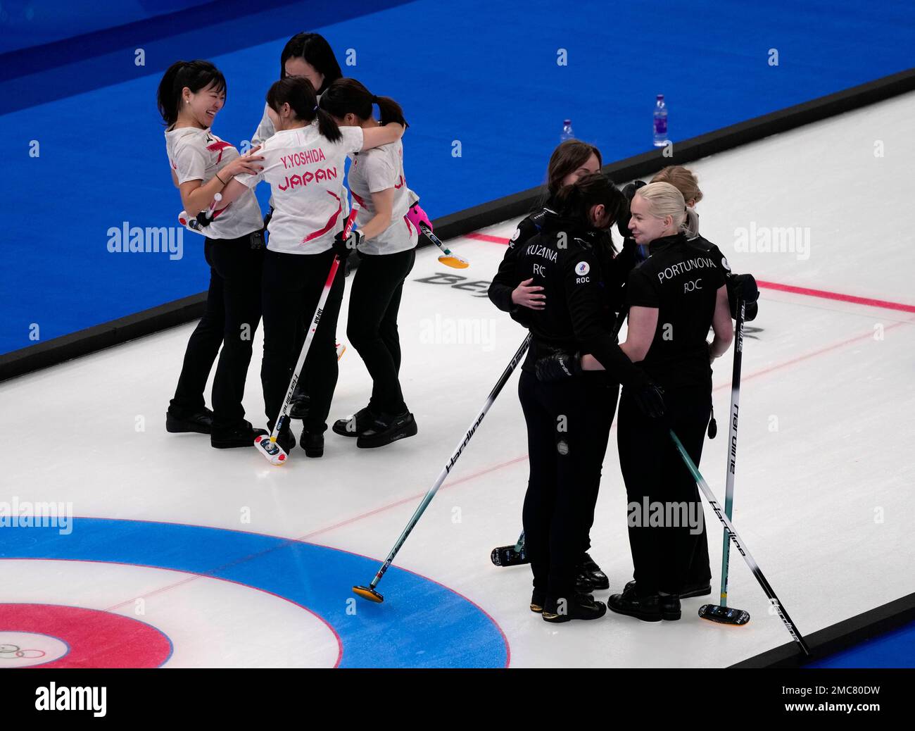 Japan's team and the Russian Olympic Committee team, huddle, after the ...