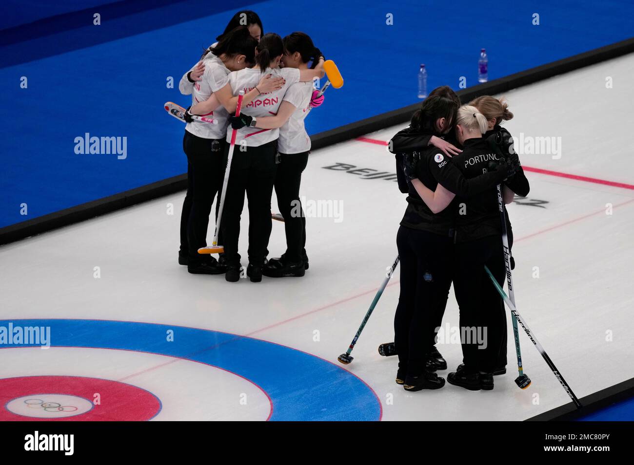 Japan's team and the Russian Olympic Committee team, huddle, after the ...