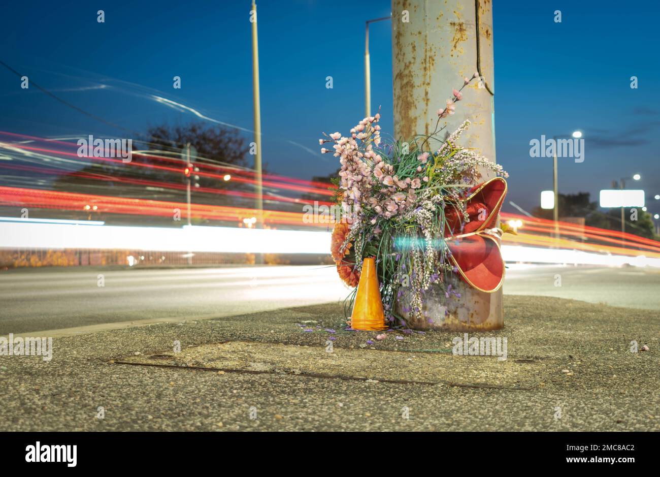 A long exposure shot of car lights and a light pillar with flowers in ...