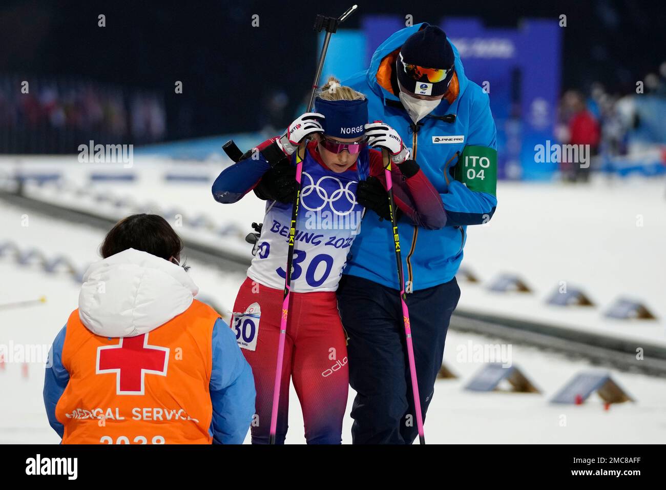 Ingrid Landmark Tandrevold of Norway is helped at the finish line ...