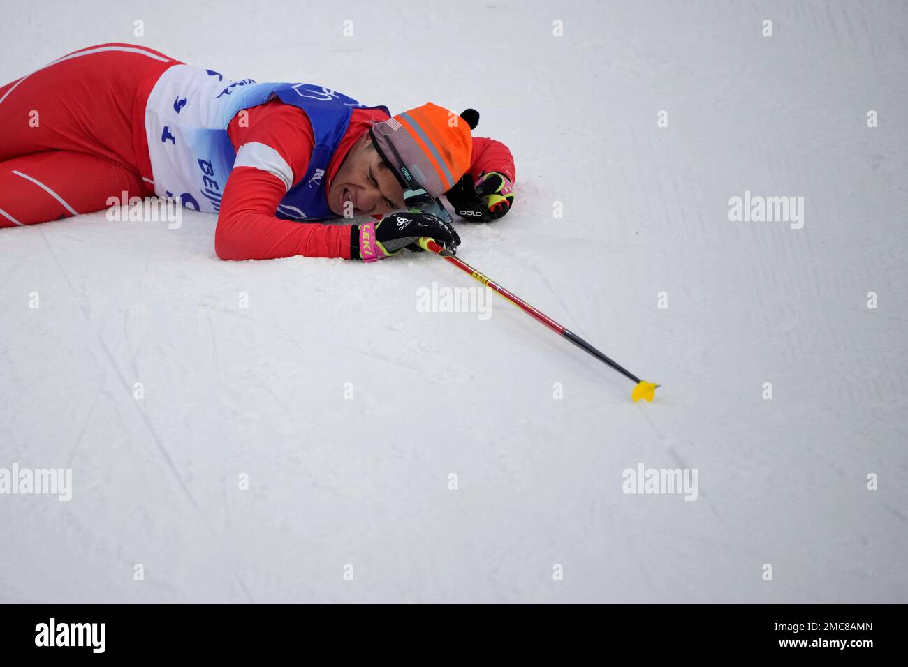 Elie Tawk, of Lebanon, rests on the snow after crossing the finish line ...
