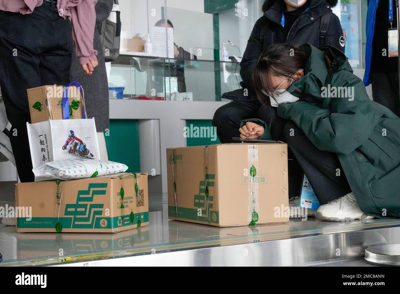 People queue with their parcels outside the post office at the Main ...