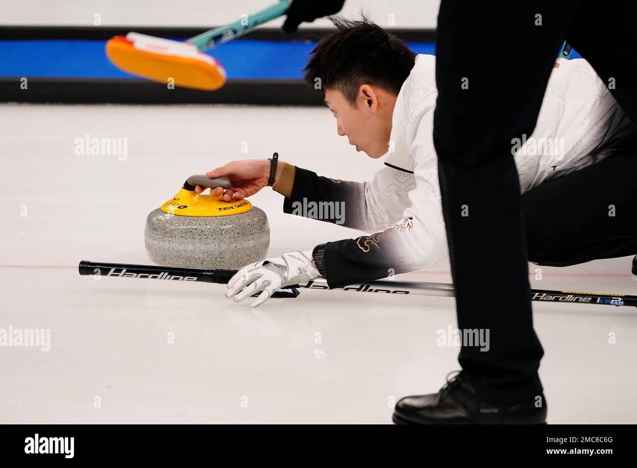 China's Ma Xiuyue throws a rock during a men's curling match against ...