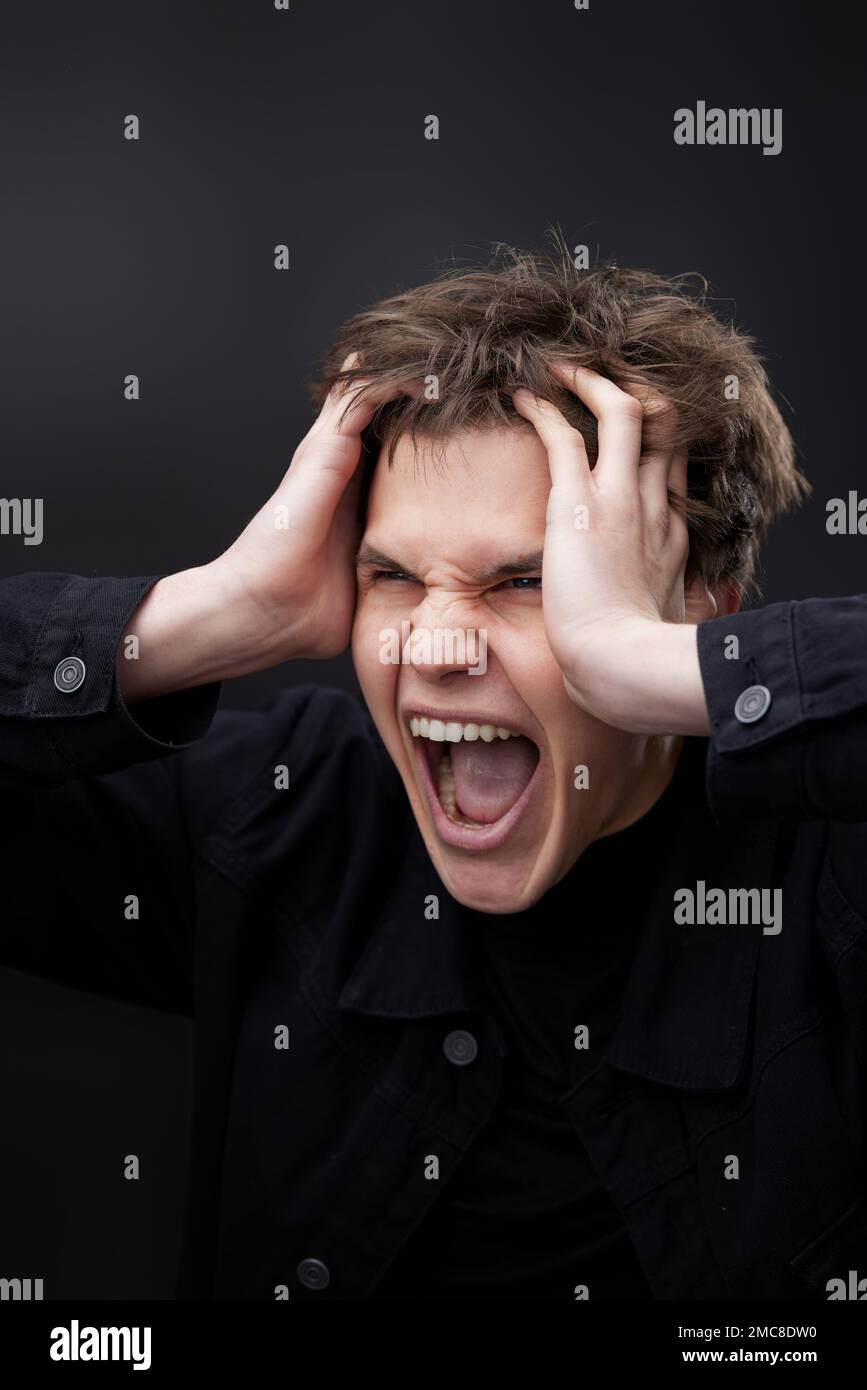 annoyed angry man in furious gesture on black background Stock Photo ...