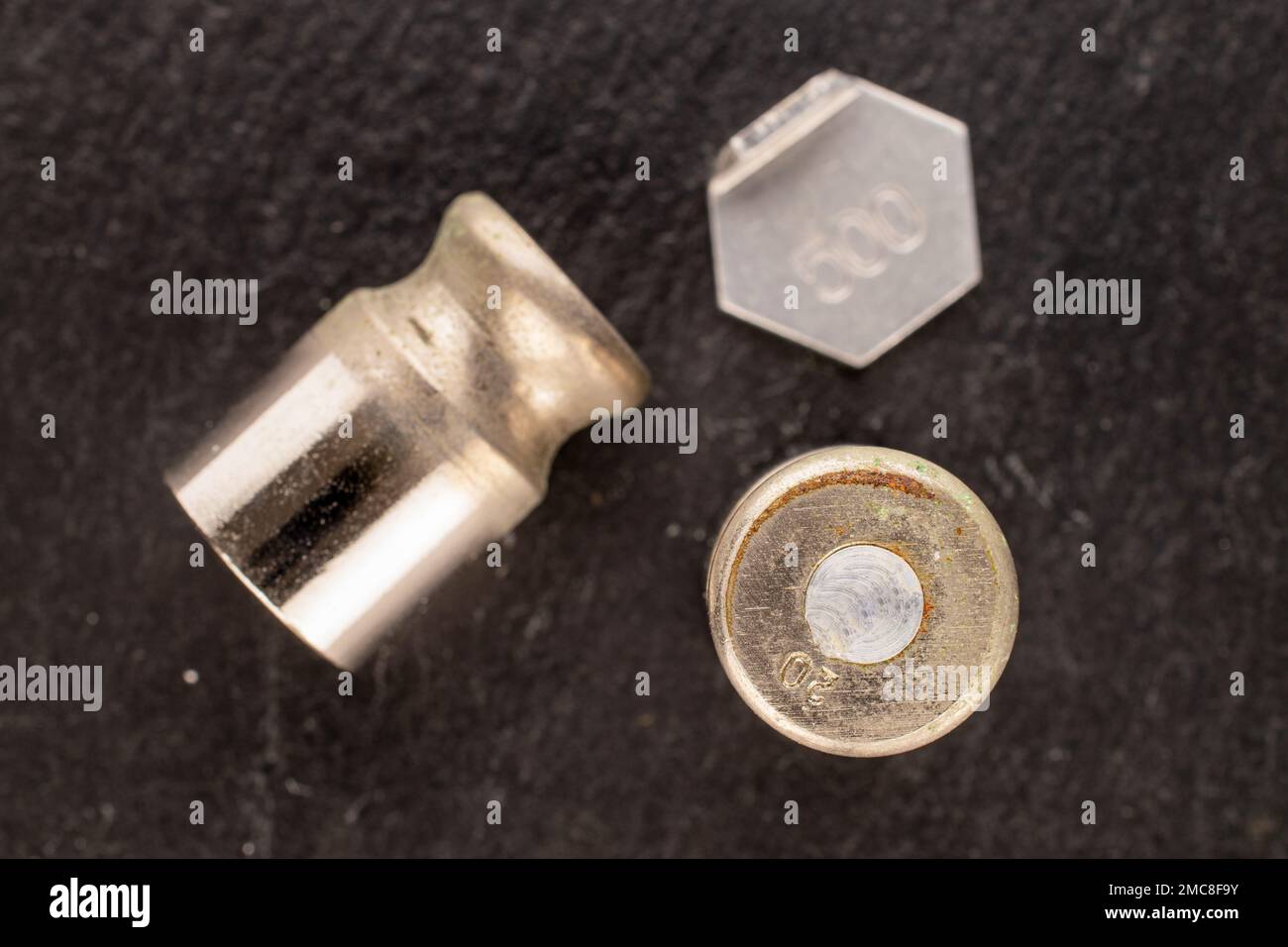 Three metal weights for old jewelry scales on slate stone, macro, top ...