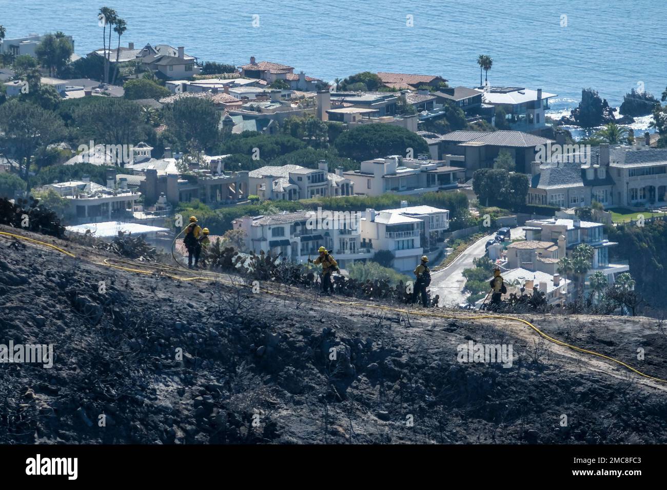 Members of hotshot hand crew work on the reaming hot spots during a ...