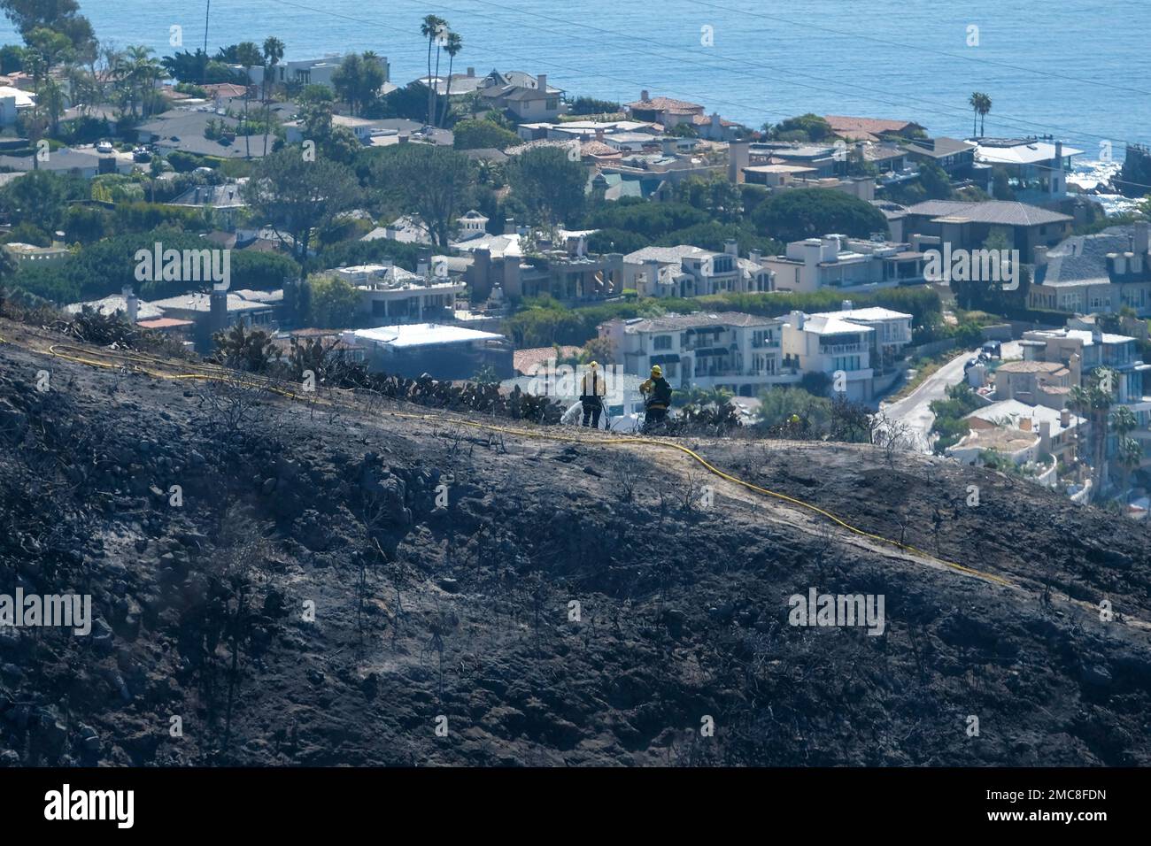 Members of hotshot hand crew work on the reaming hot spots during a ...