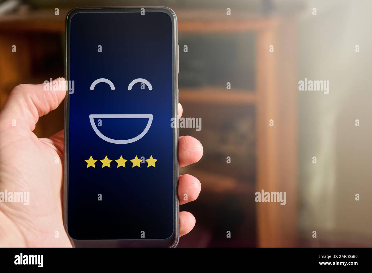 Closeup of male hand holding mobile phone with smiling happy face and ...