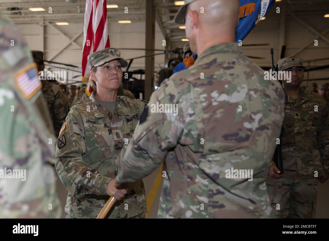 U.S. Army Command Sgt. Maj. Christina M. Lewis passes the guidon to ...