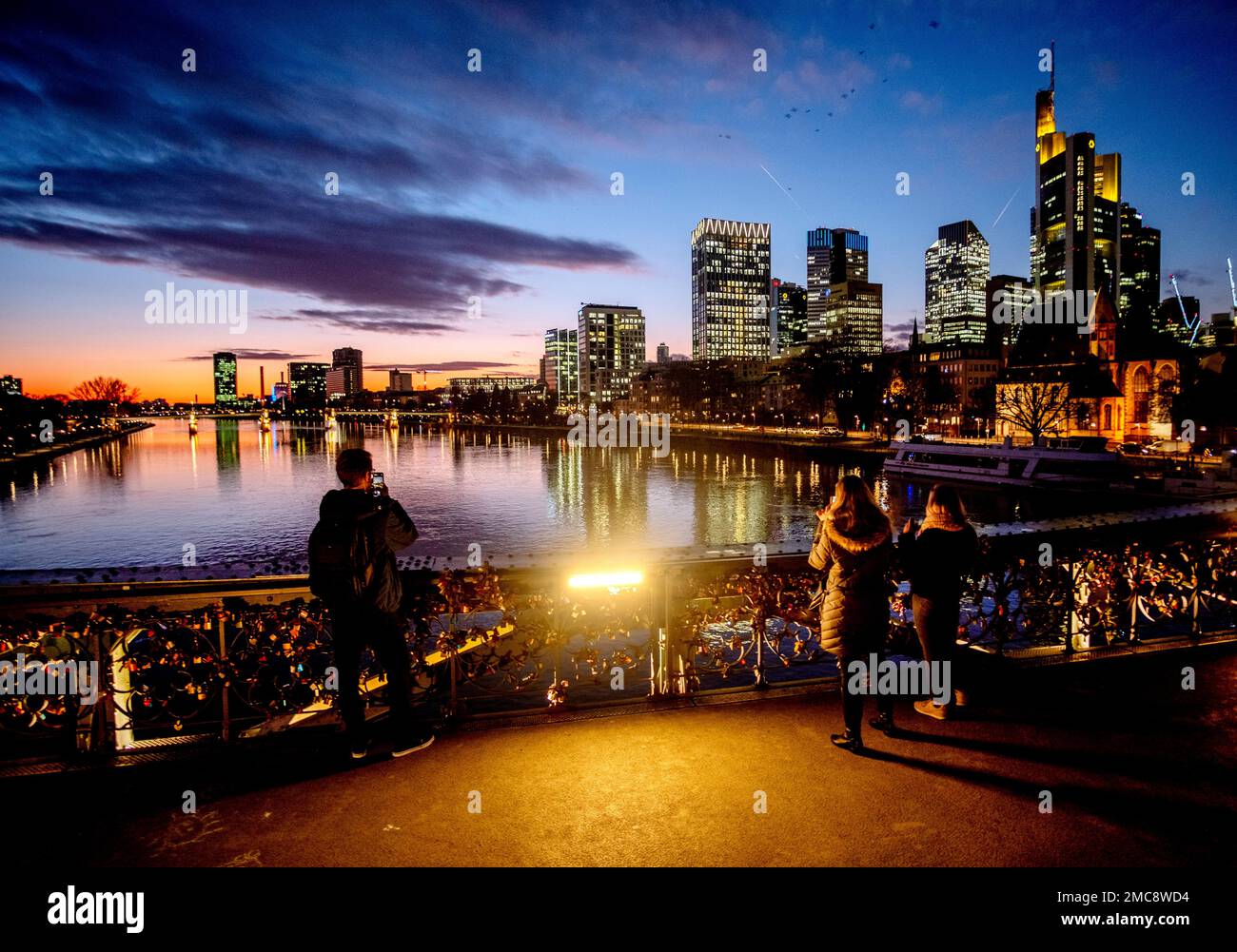 People take a view from a bridge over the river Main in Frankfurt ...