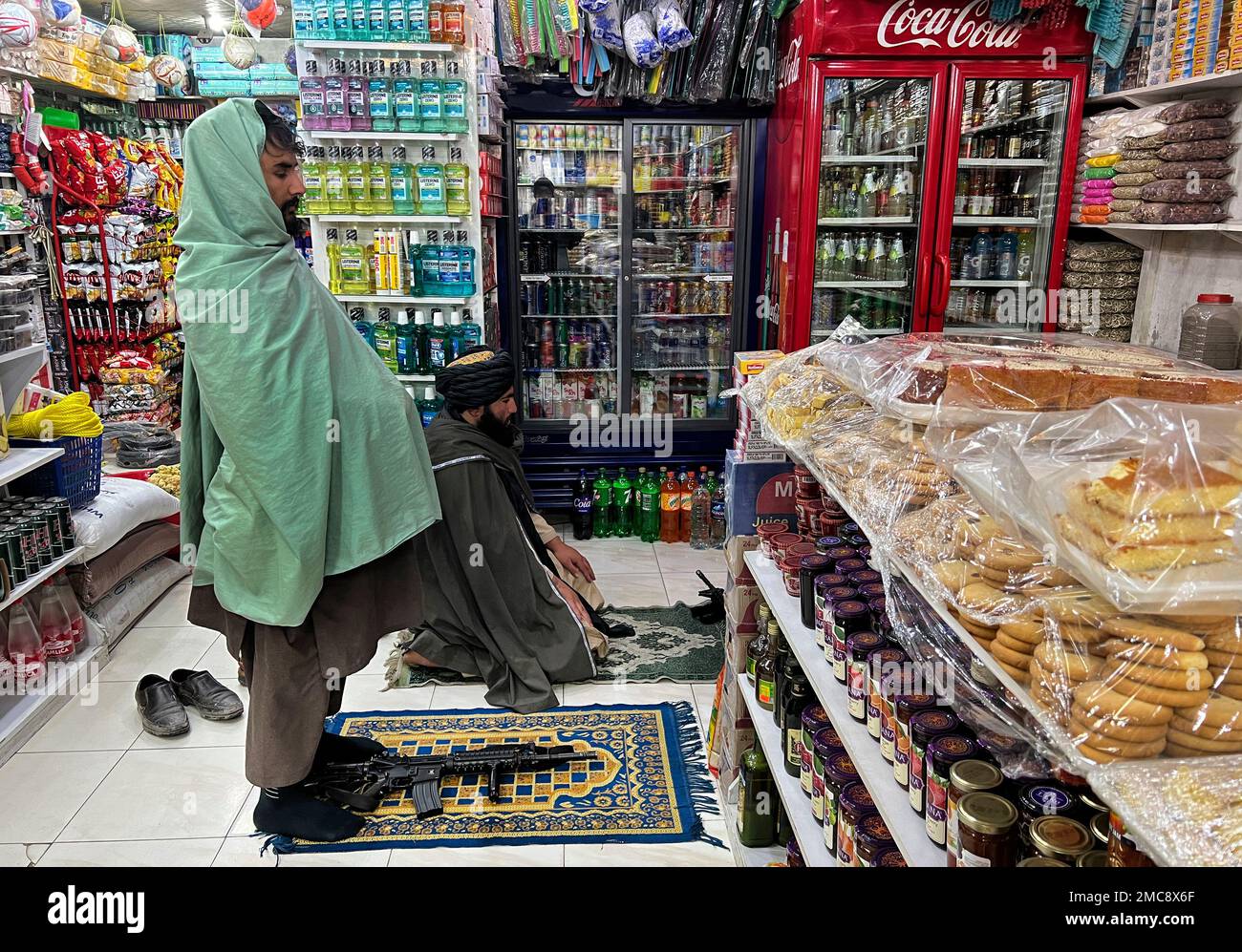Taliban fighters pray the sunset Muslim prayer inside a supermarket, in ...
