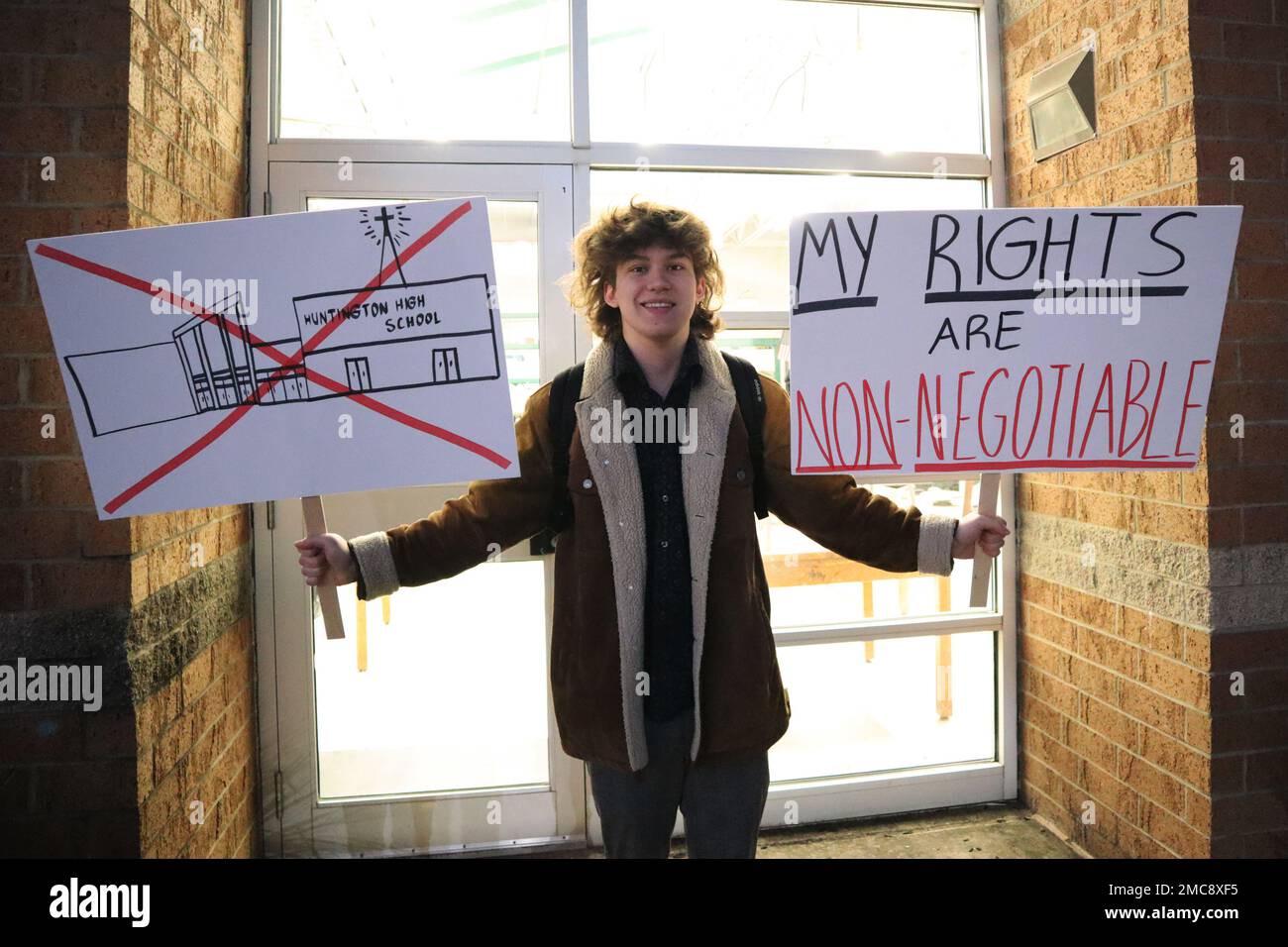 Huntington High School senior Max Nibert holds signs he plans to use ...