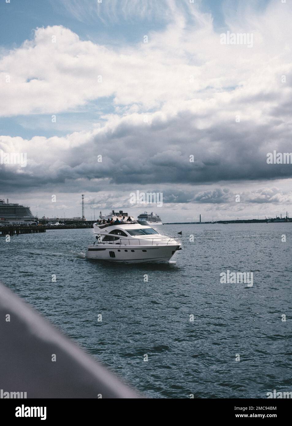 A vertical shot of a white boat swimming in the sea during the ...