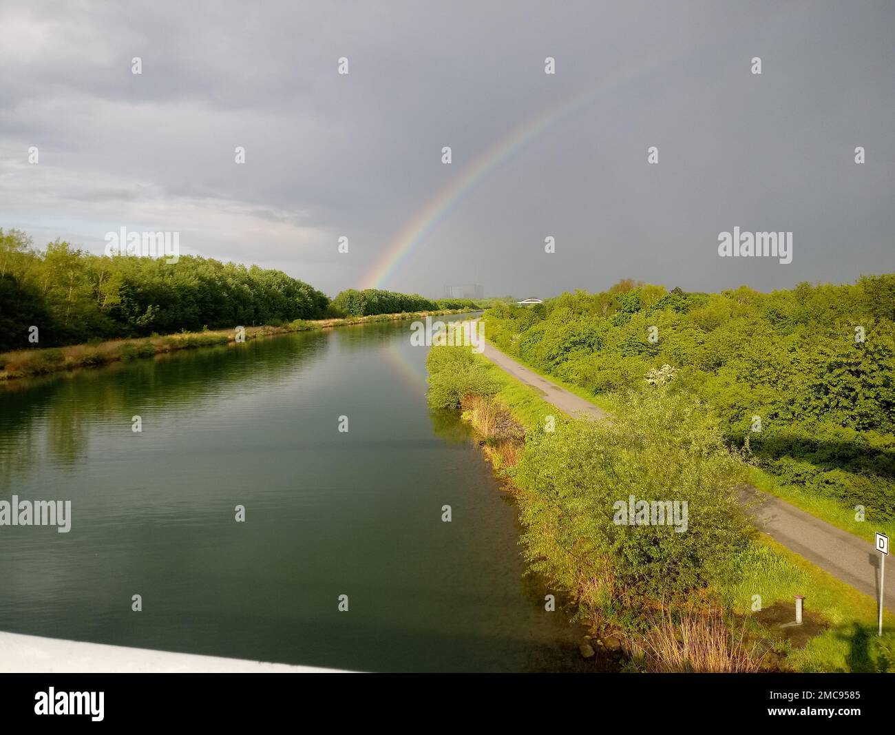 The beautiful rainbow over a tranquil river surrounded by green ...