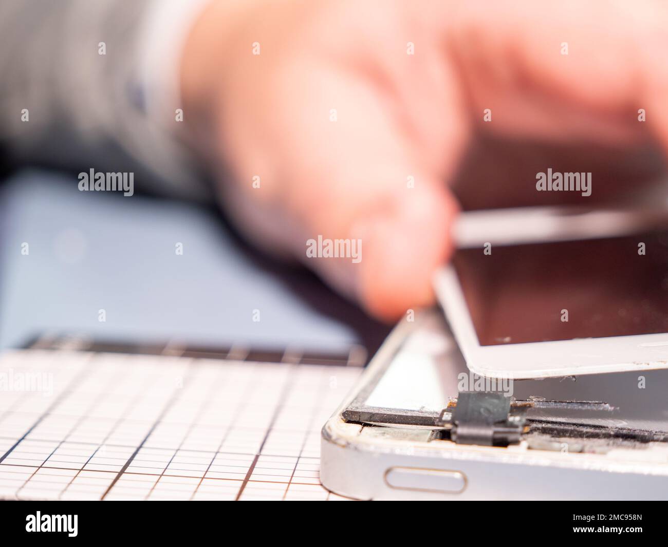 A technician repairs a smartphone in a laboratory with copy space ...