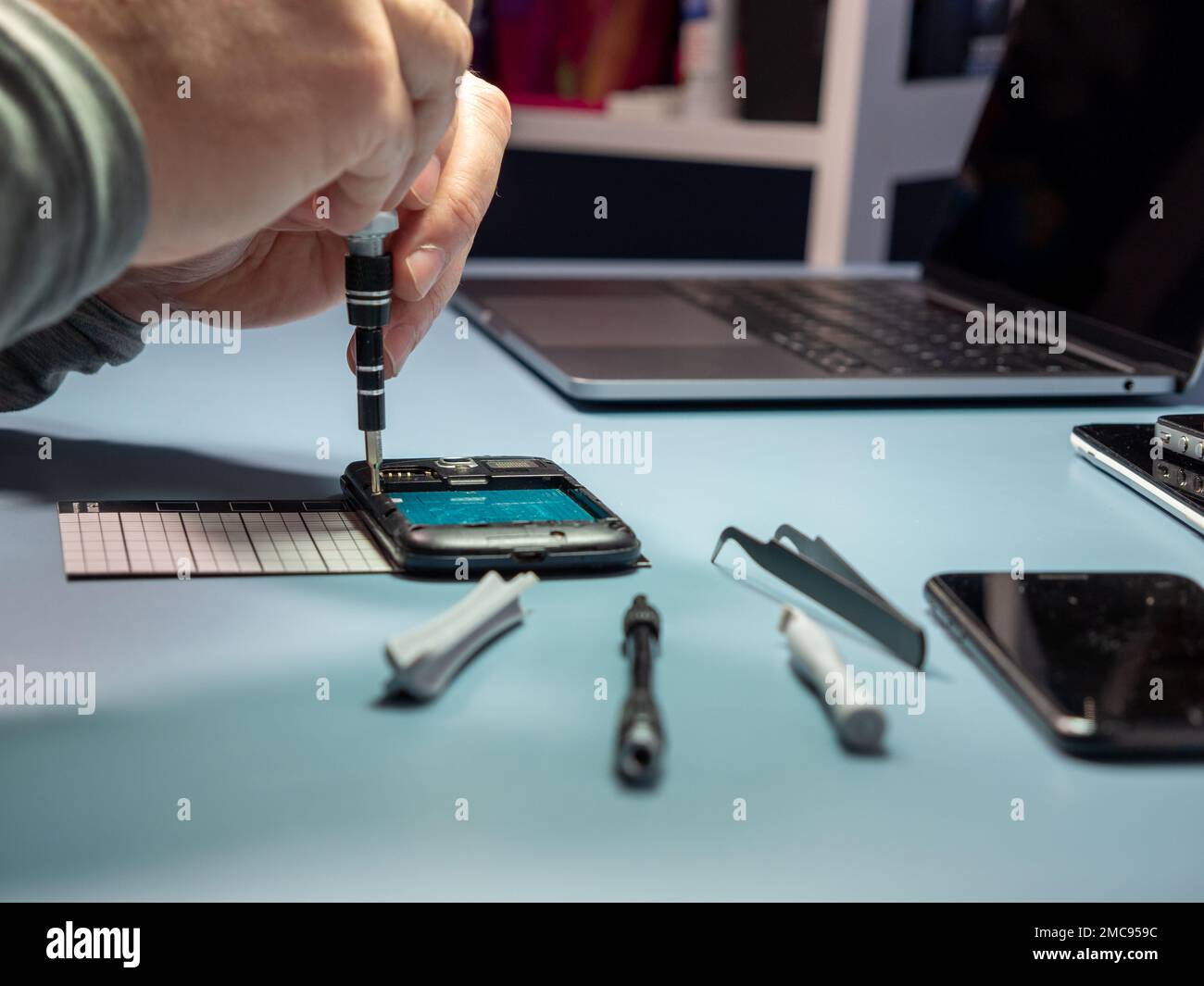 A technician repairs a smartphone in a laboratory with copy space ...
