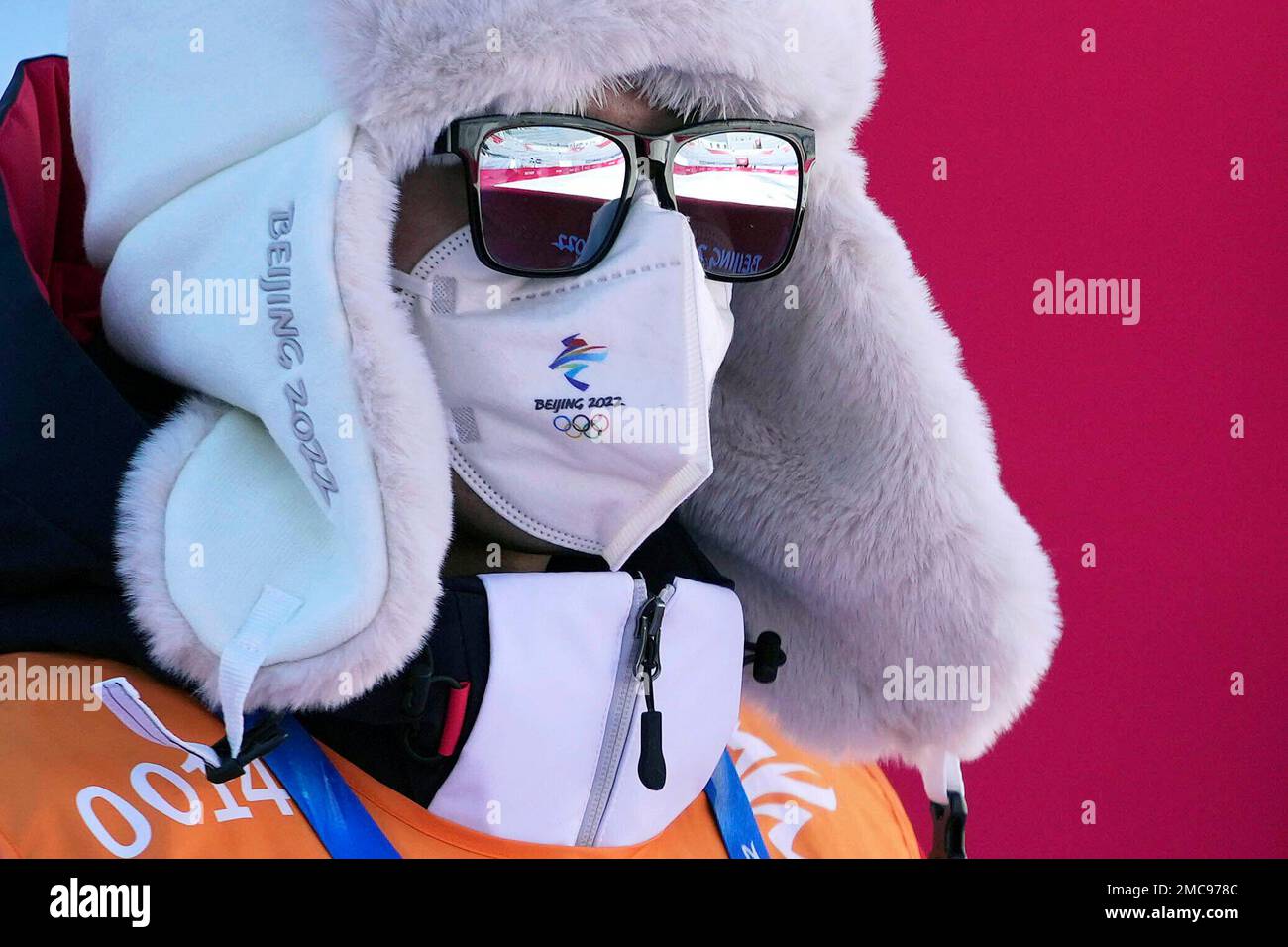 A man wears a face mask displaying the Olympic rings at the ski jumping ...