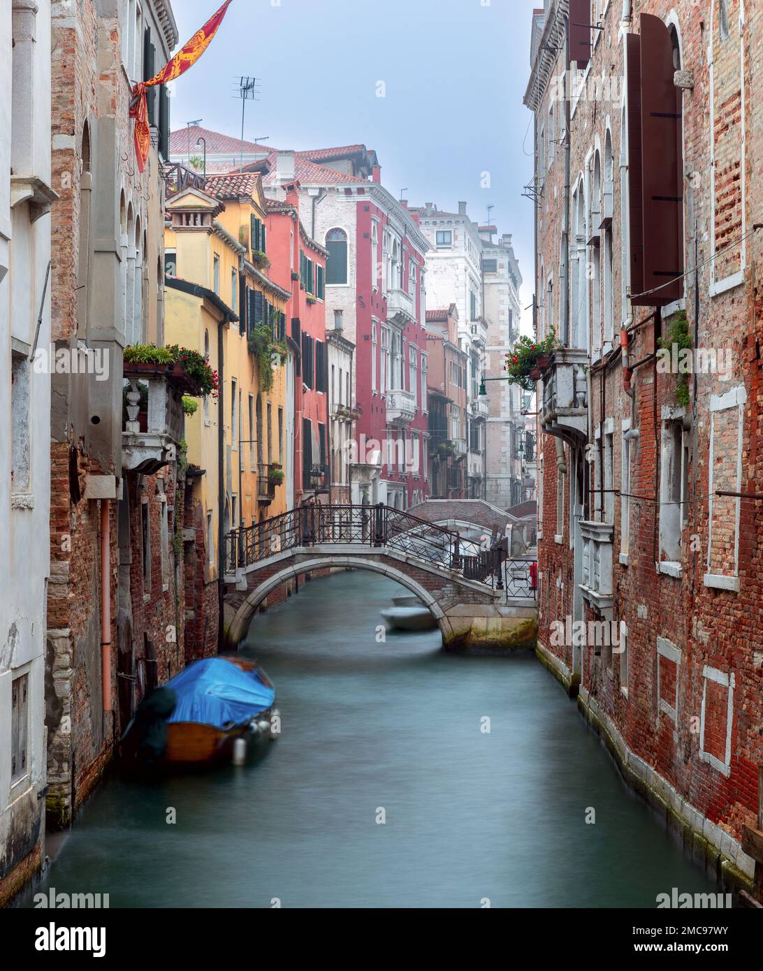 Facades of old traditional medieval houses along the canal at sunrise ...
