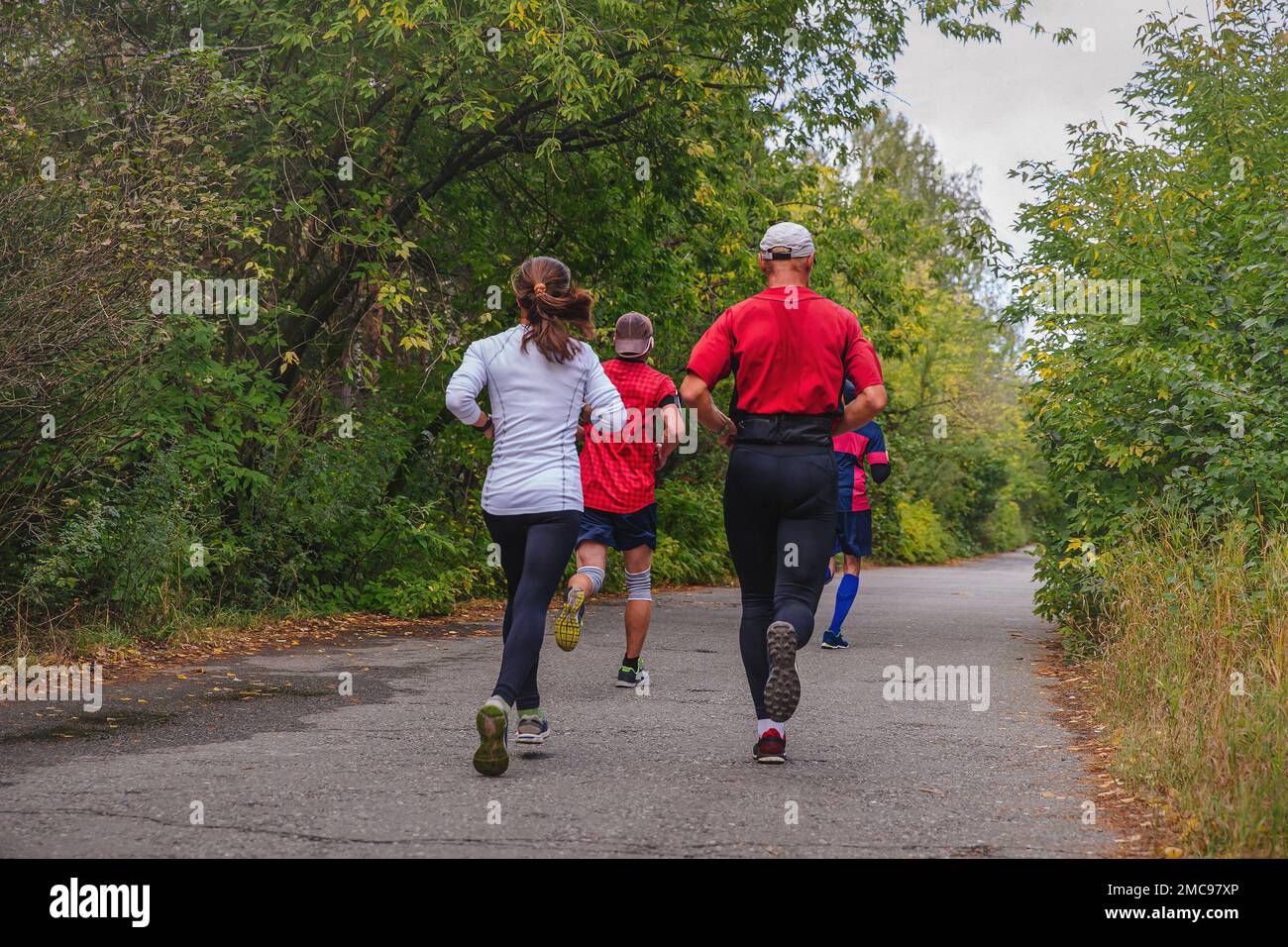 group runners men and woman run race in autumn park Stock Photo - Alamy