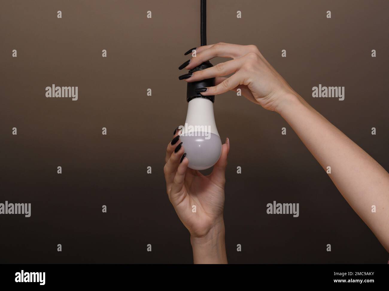 Women's hands screw in a light bulb. led lamp Stock Photo - Alamy