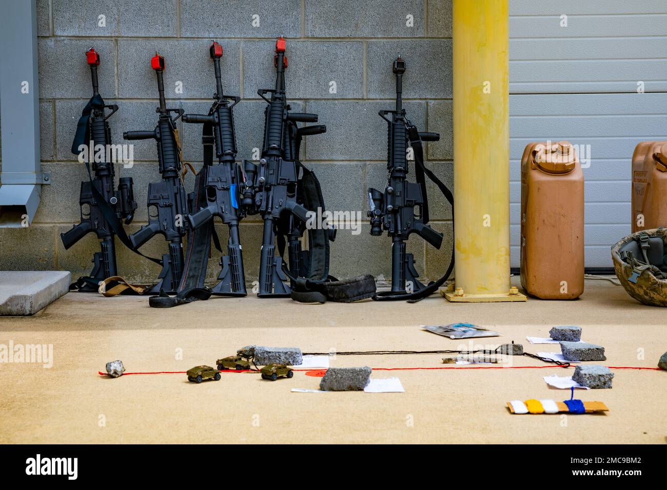 M4A1 carbines rest against a wall behind a terrain model at the ...