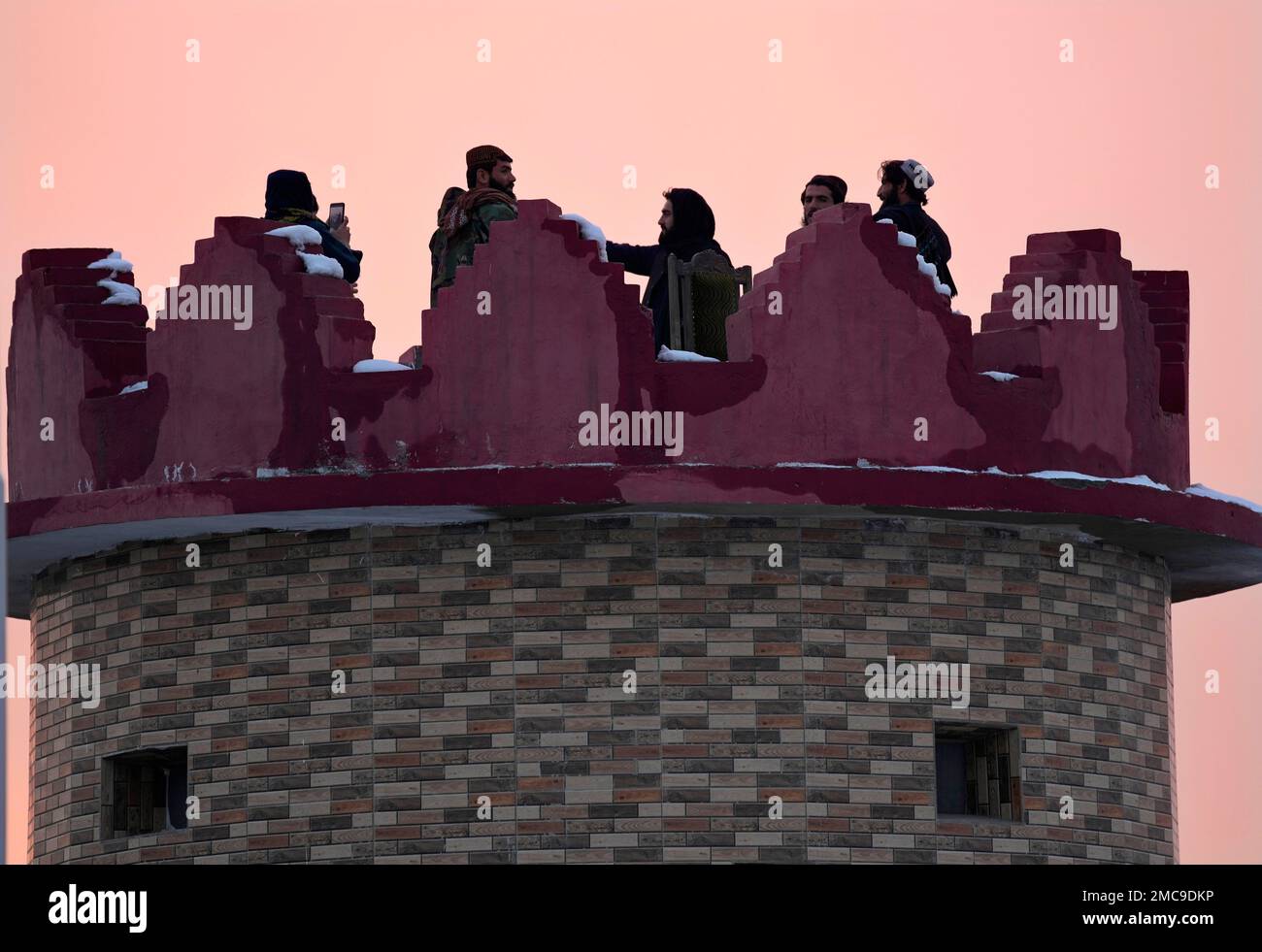 Taliban fighters watch the sunset on a tower, in Kabul, Afghanistan ...