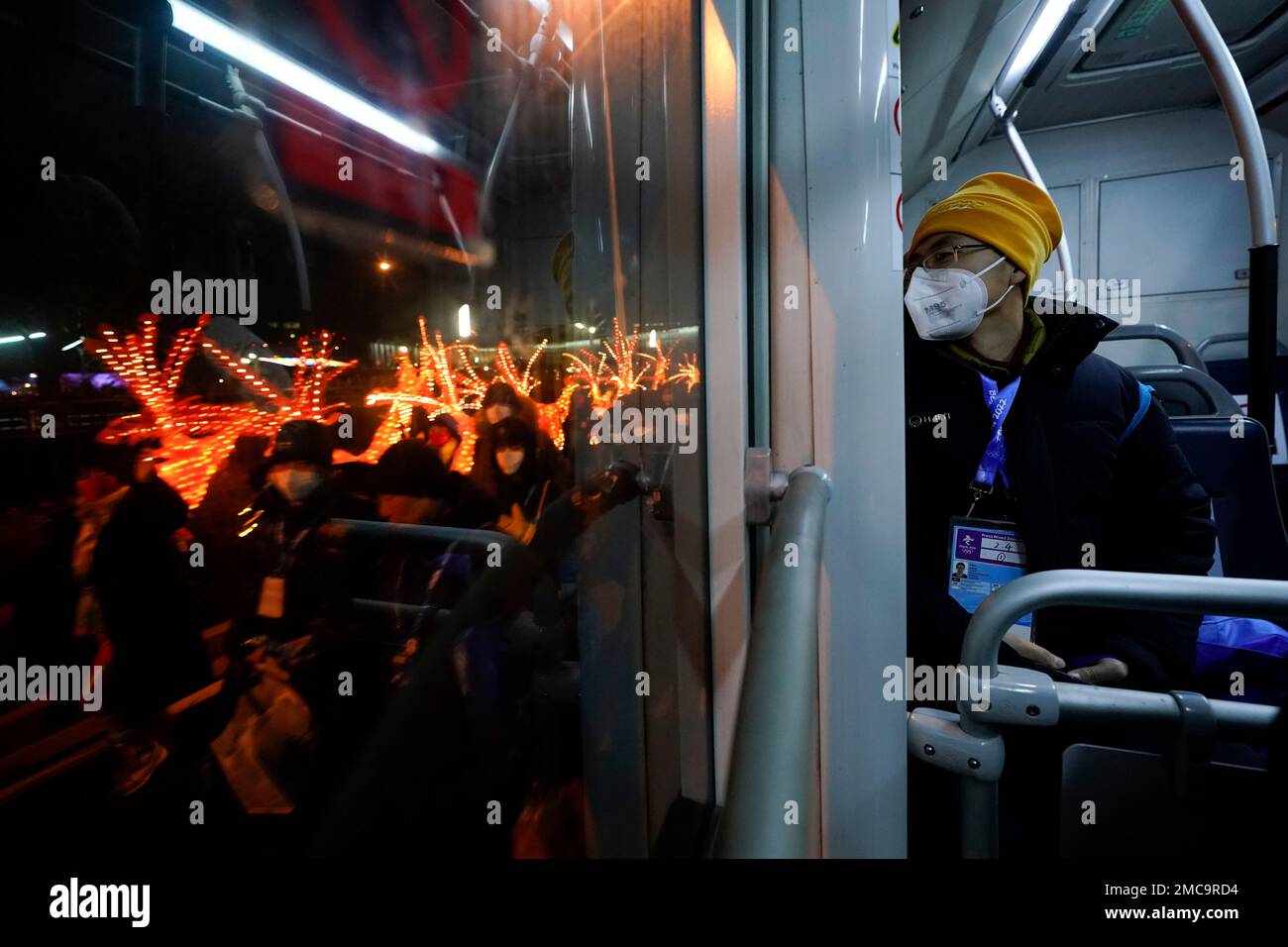 A journalist looks out the window of an Olympic shuttle bus as ...