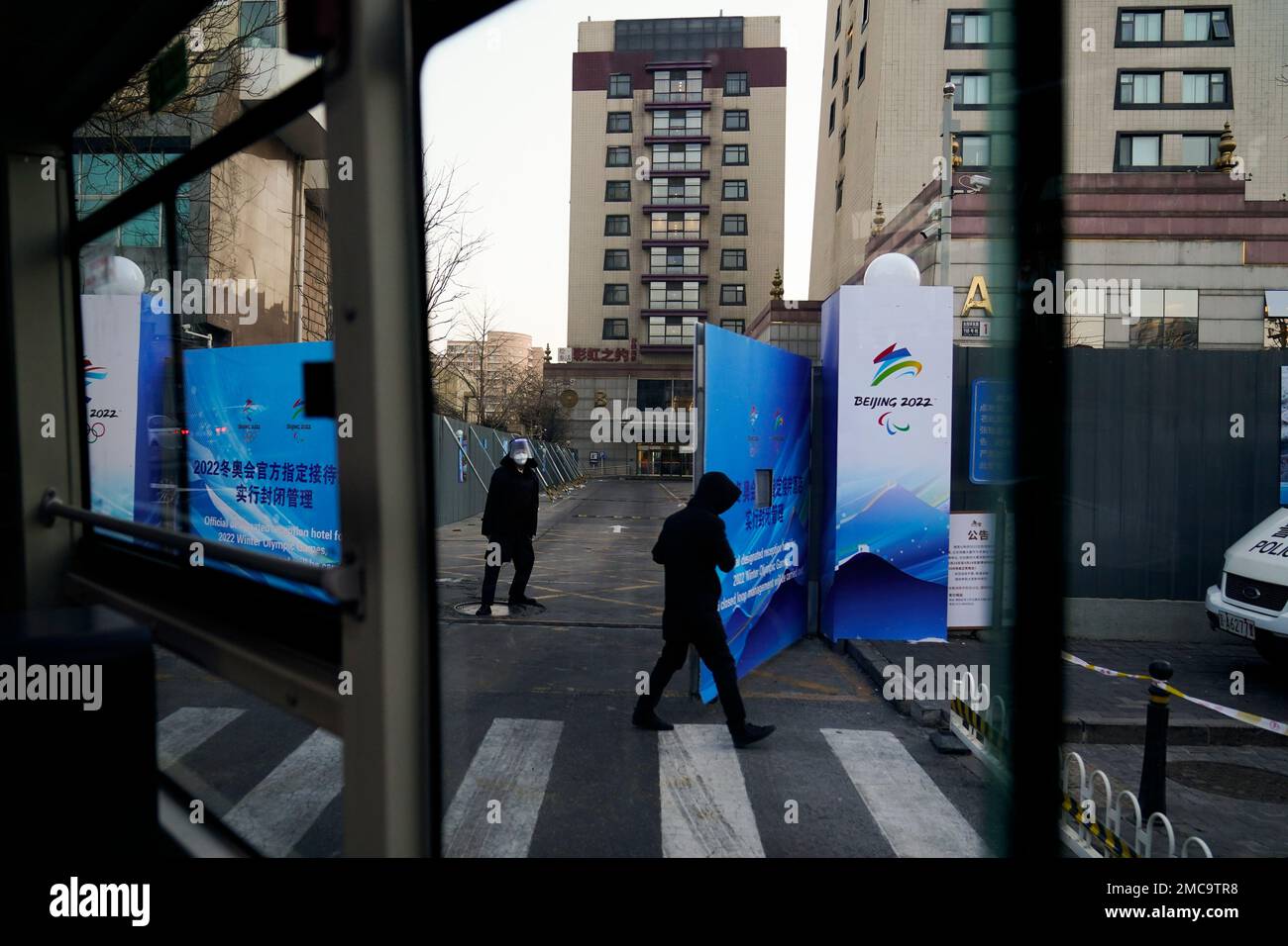 FILE - A guard opens the gate as an Olympic shuttle bus pulls into a ...