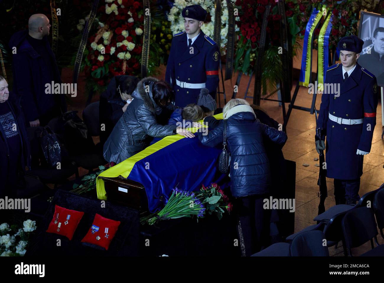 Kyiv, Ukraine. 21st Jan, 2023. Family members grieve at the casket of ...
