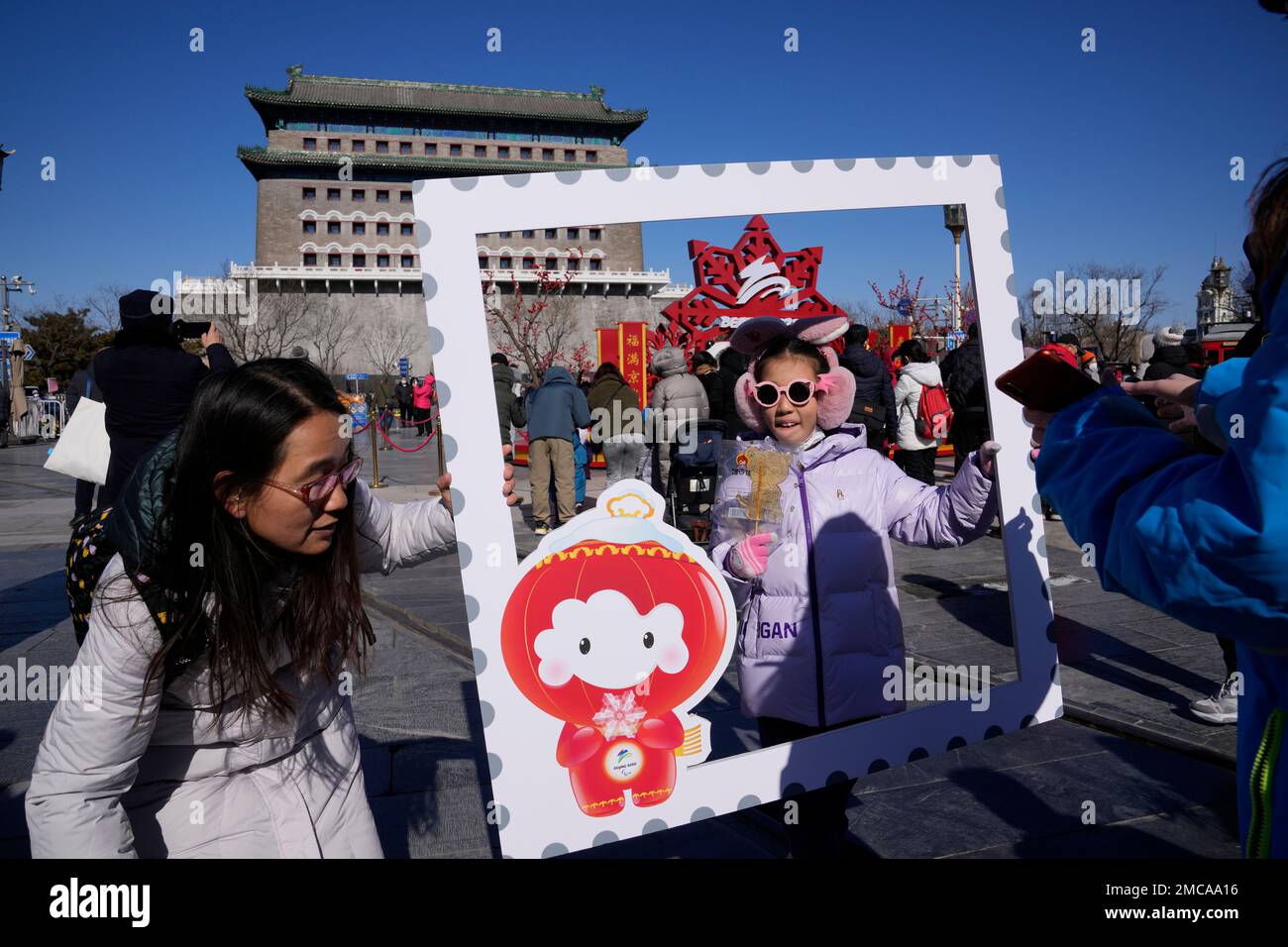Residents pose for photos with a cutout showing the Paralympic mascot ...