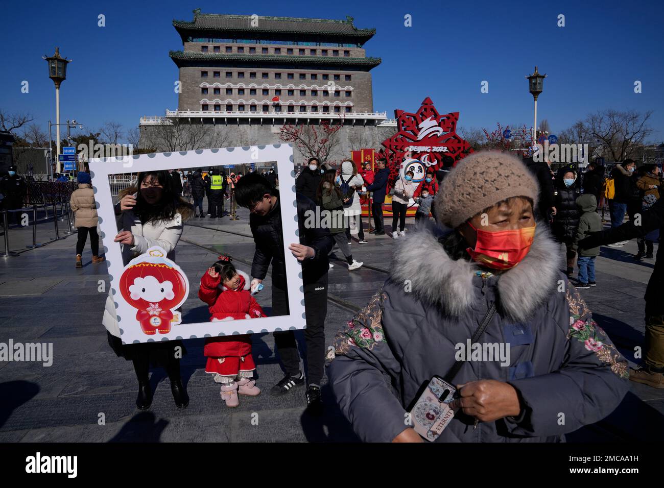 Residents pose for photos with a cutout showing the Paralympic mascot ...