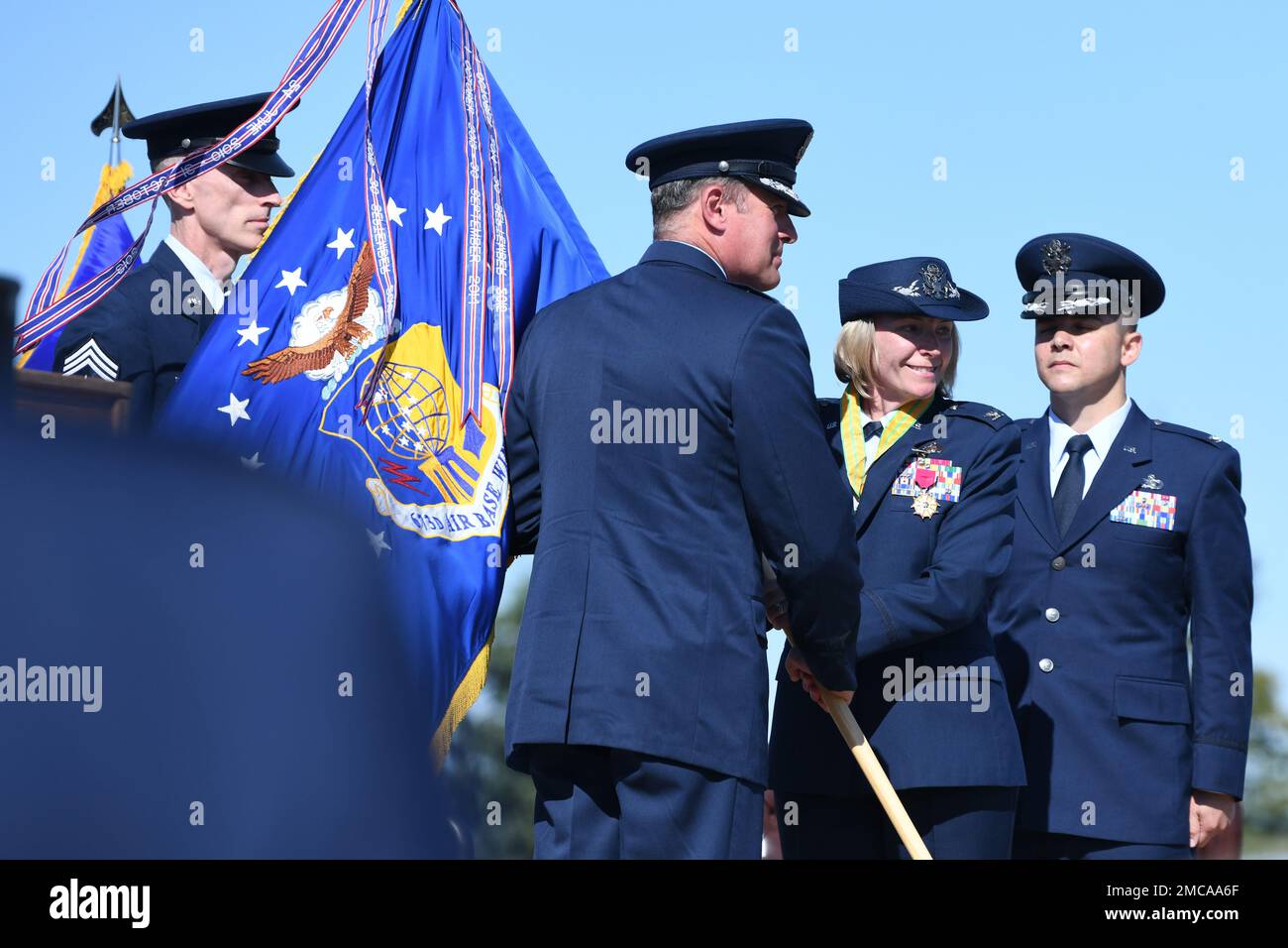 U.S. Air Force Col. Kirsten G. Aguilar, center, passes the 673d Air Base Wing colors to U.S. Air ...