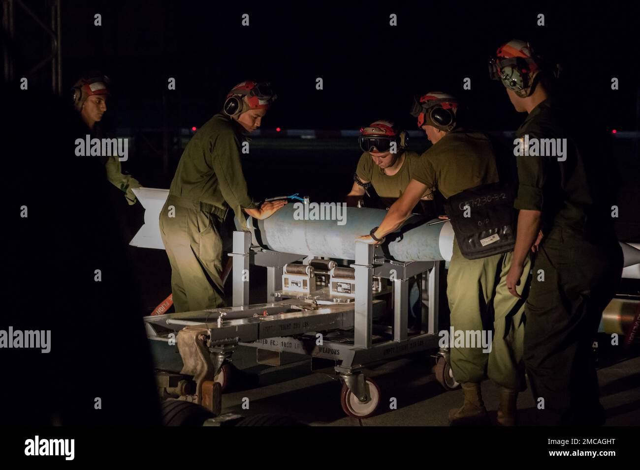 U.S. Marines with Marine Fighter Attack Squadron (VMFA) 242 prepare to load a GBU-12 Paveway II ...