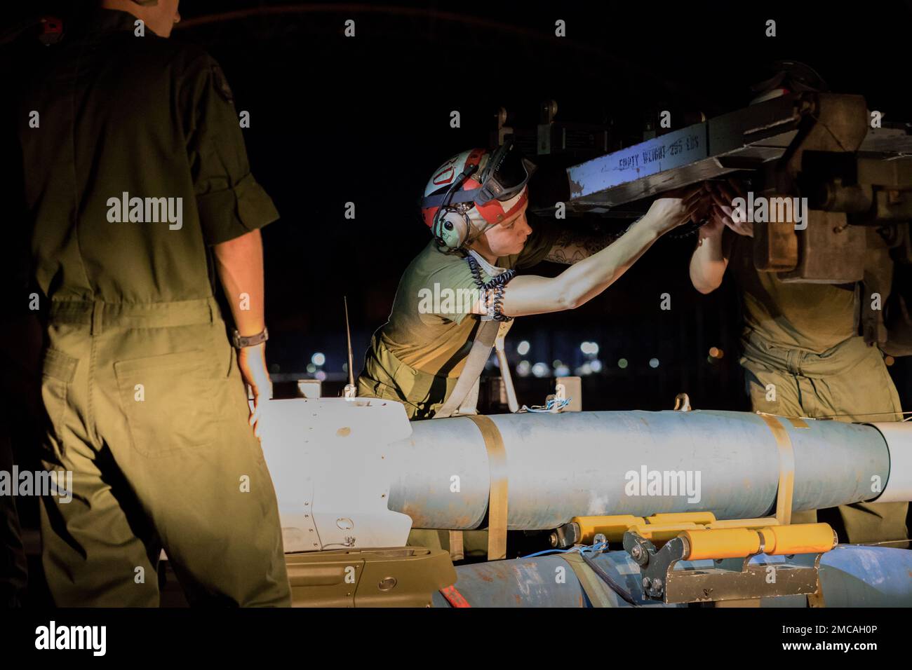 U.S. Marines with Marine Fighter Attack Squadron (VMFA) 242 load a GBU-12 Paveway II laser ...