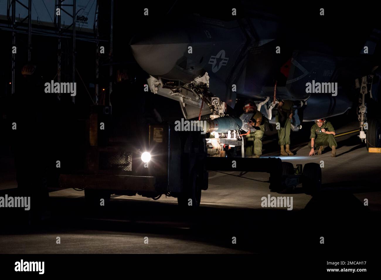 U.S. Marines with Marine Fighter Attack Squadron (VMFA) 242 load a GBU-12 Paveway II laser ...