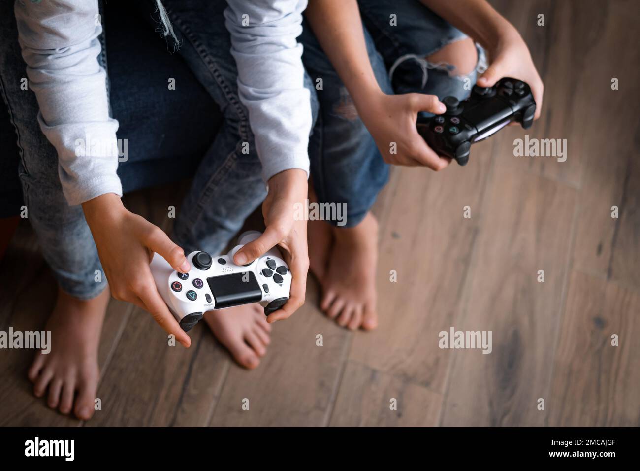 kids hands with joysticks, two children siblings playing video game ...
