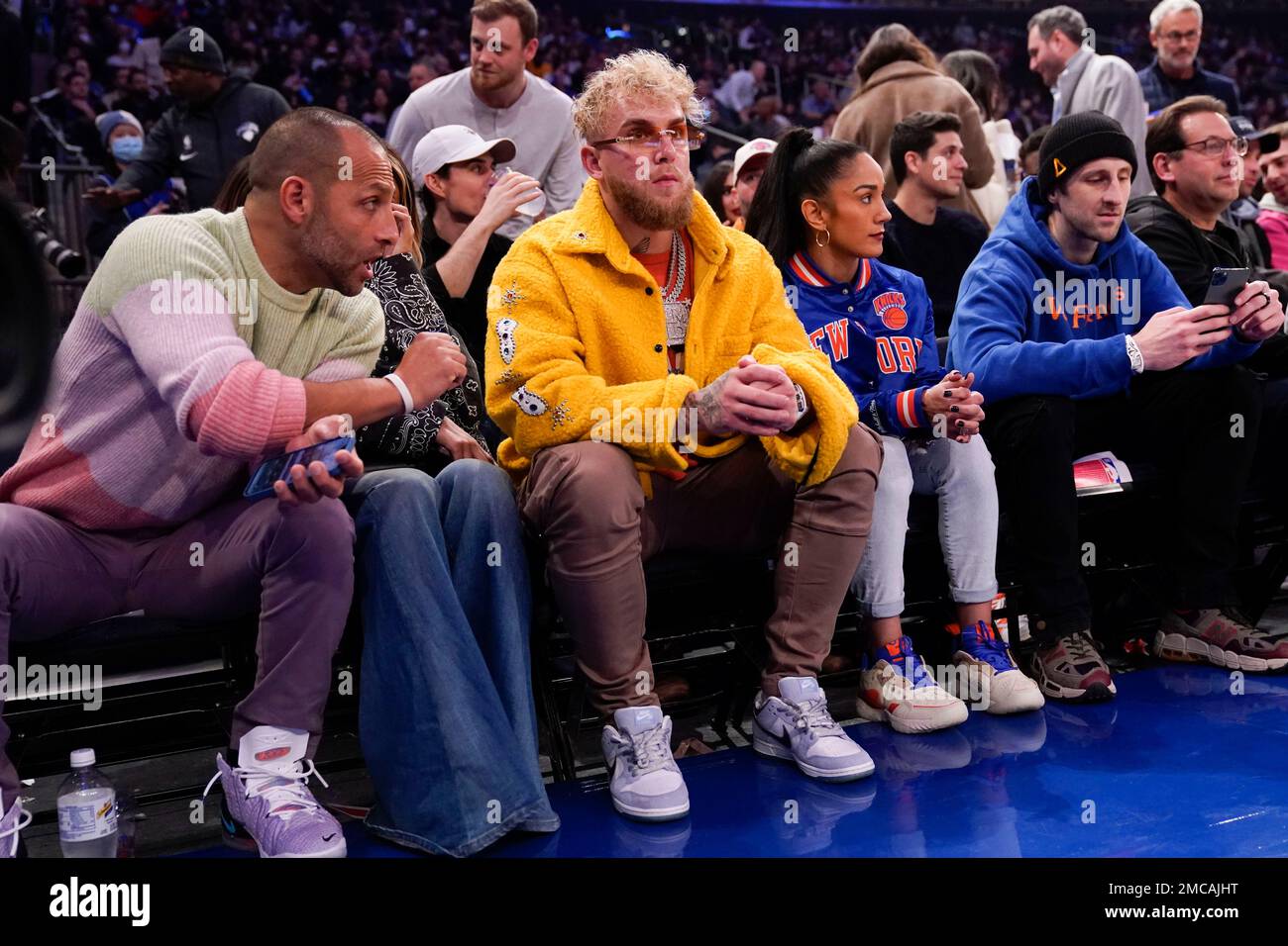 Jake Paul, in yellow, attends an NBA basketball game between the New ...
