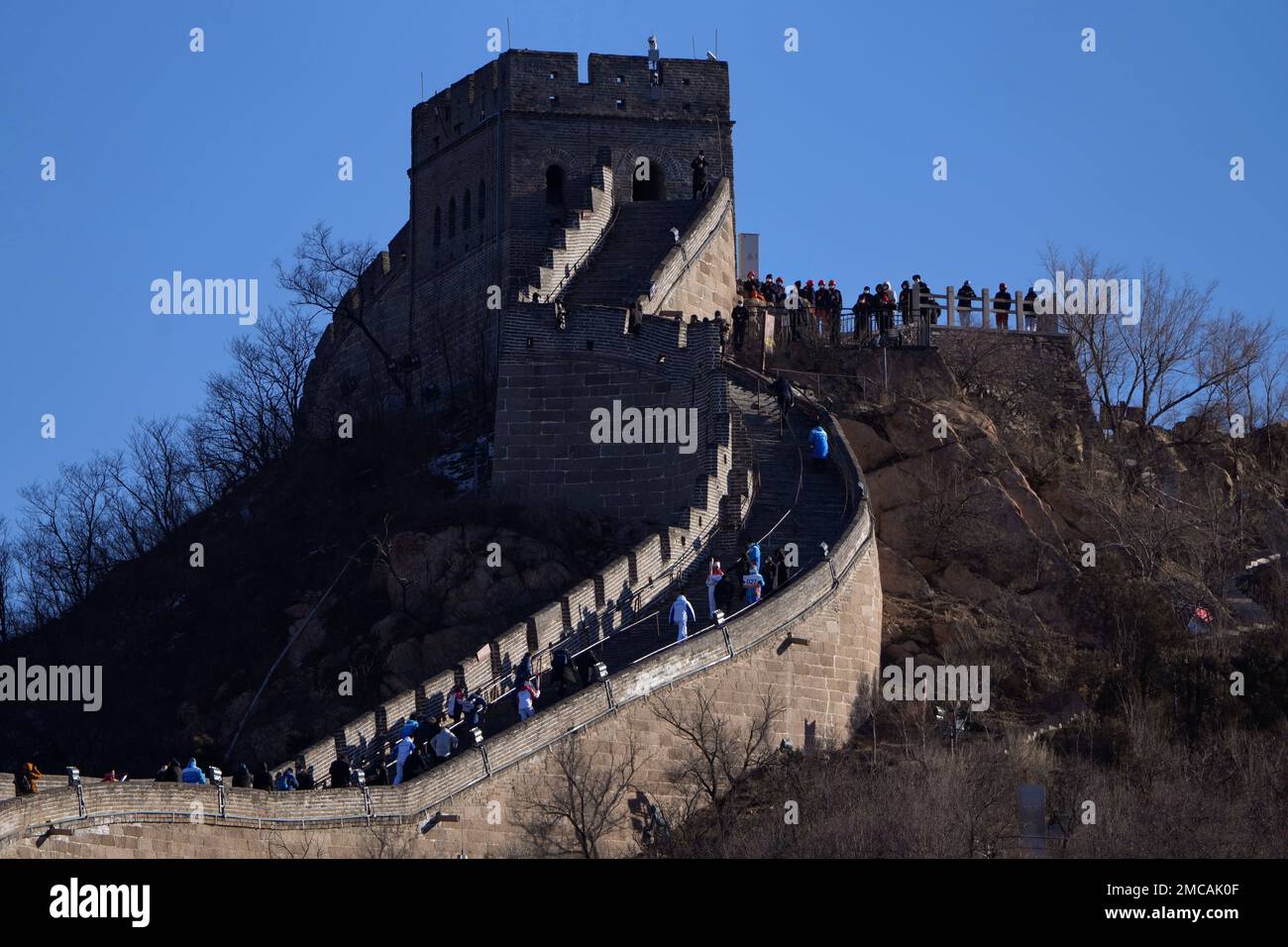 A torch bearer runs up the slope of the Great Wall during the torch ...