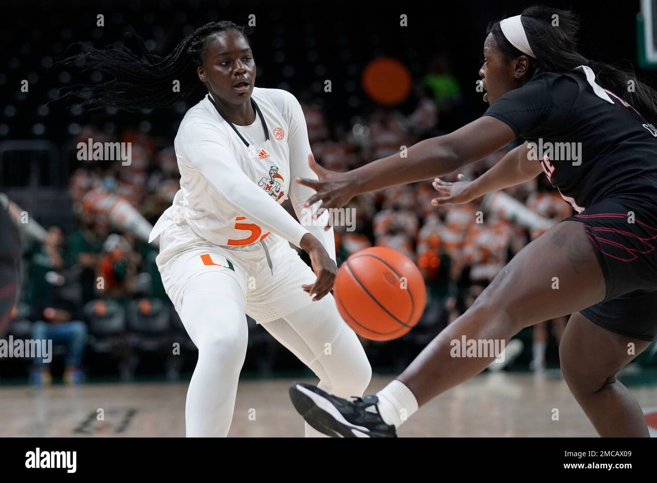Miami forward Maeva Djaldi-Tabdi, left, passes past Louisville forward ...