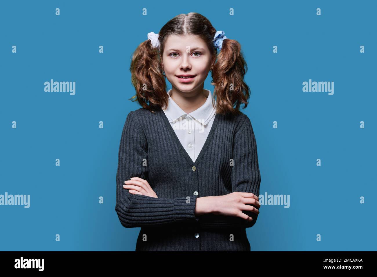 Portrait of smiling child schoolgirl on blue studio background Stock ...