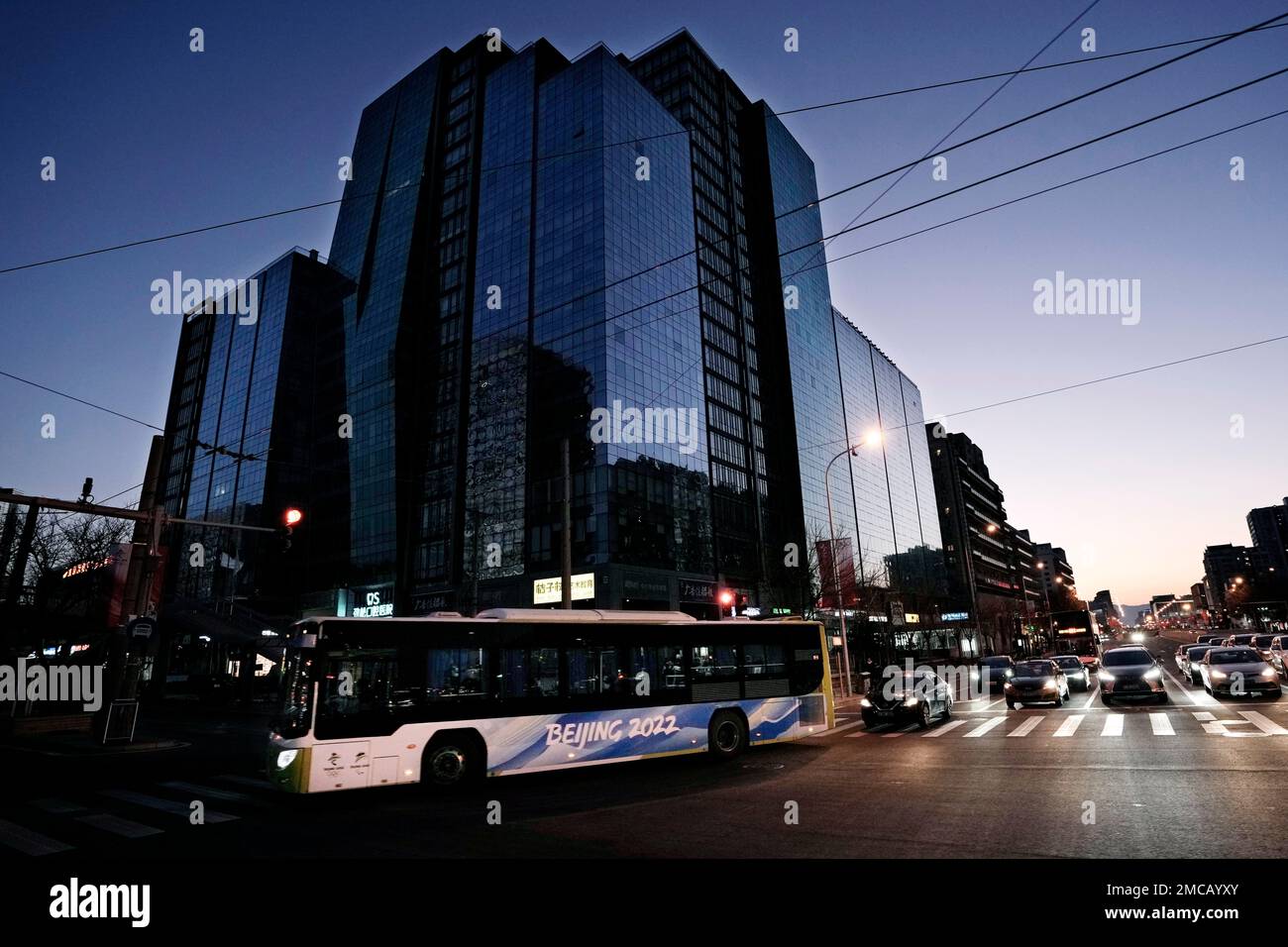 A bus with an advertisement for the Olympics makes its way on a street ...