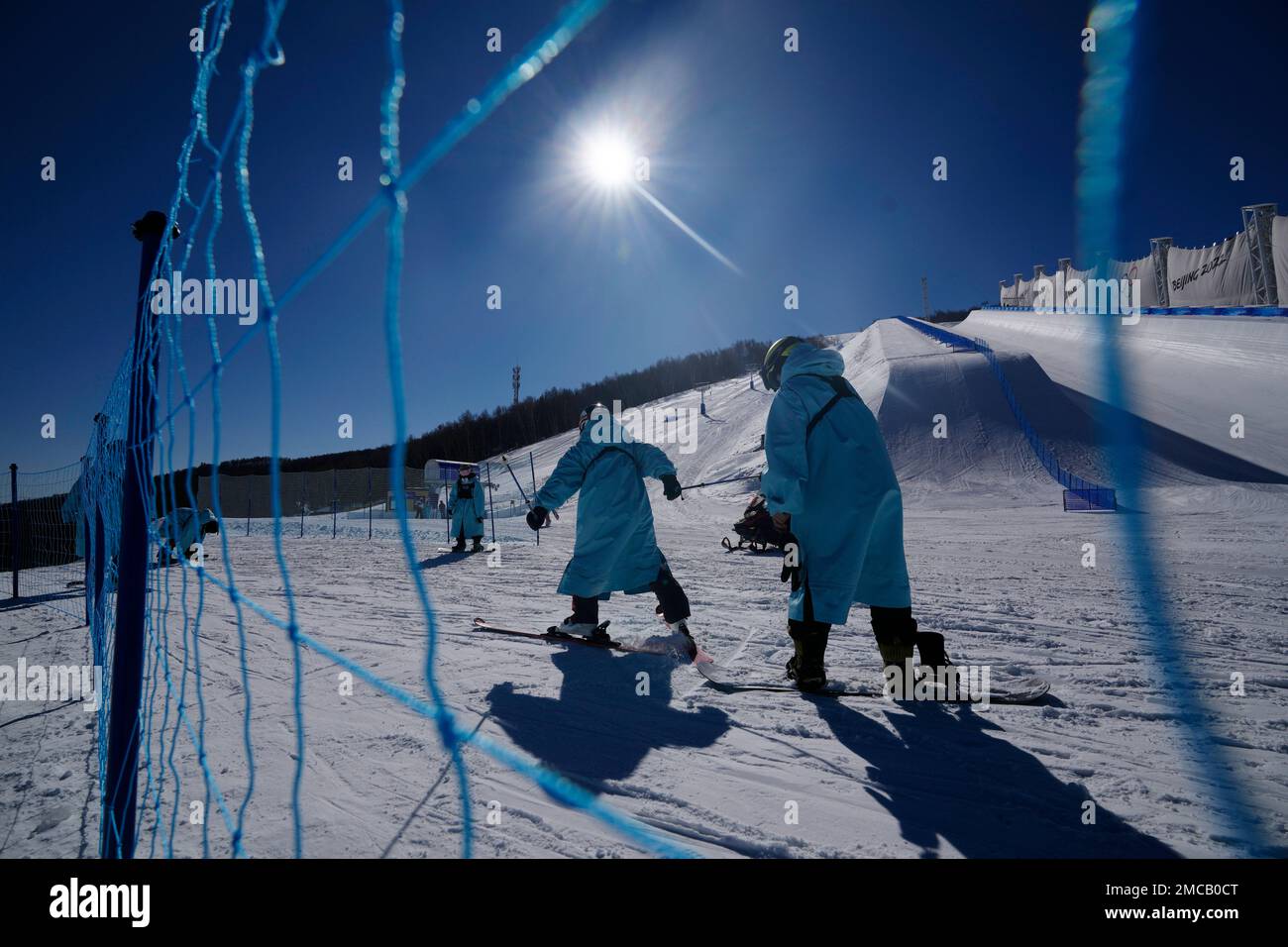 Workers ski around the half-pipe course ahead of the 2022 Winter ...