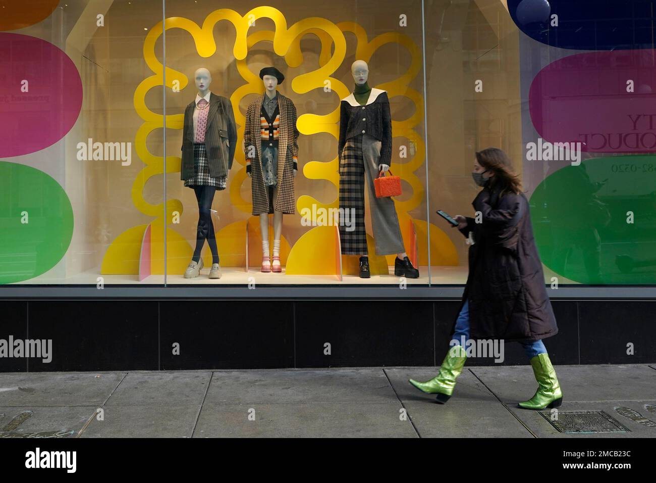 A pedestrian passes a window display of clothing for sale at the ...