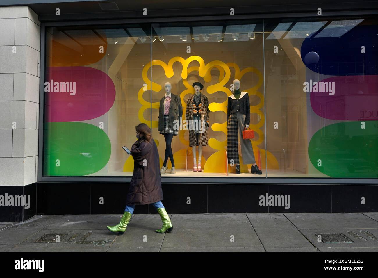 A pedestrian passes a window display of clothing for sale at the ...