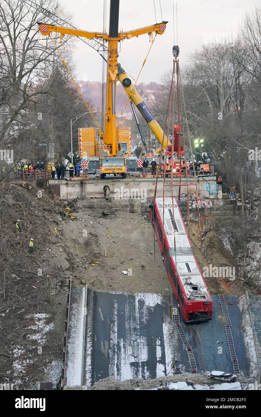 Cranes lift the bus that was on a bridge when it collapsed Friday ...